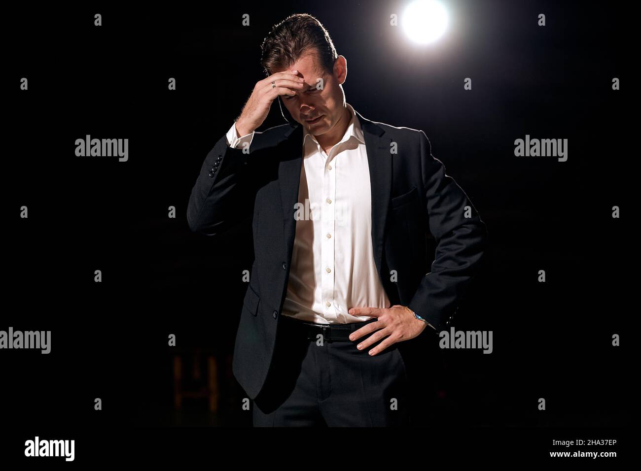 Young american businessman looking down and thinking while standing on ...