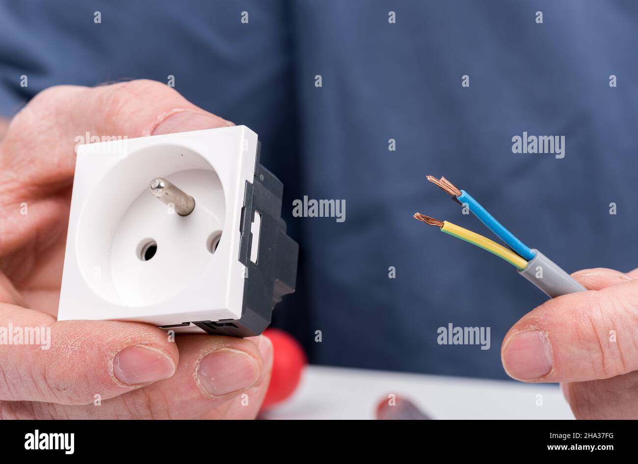 Hand holding an electrical outlet and a power cable Stock Photo - Alamy
