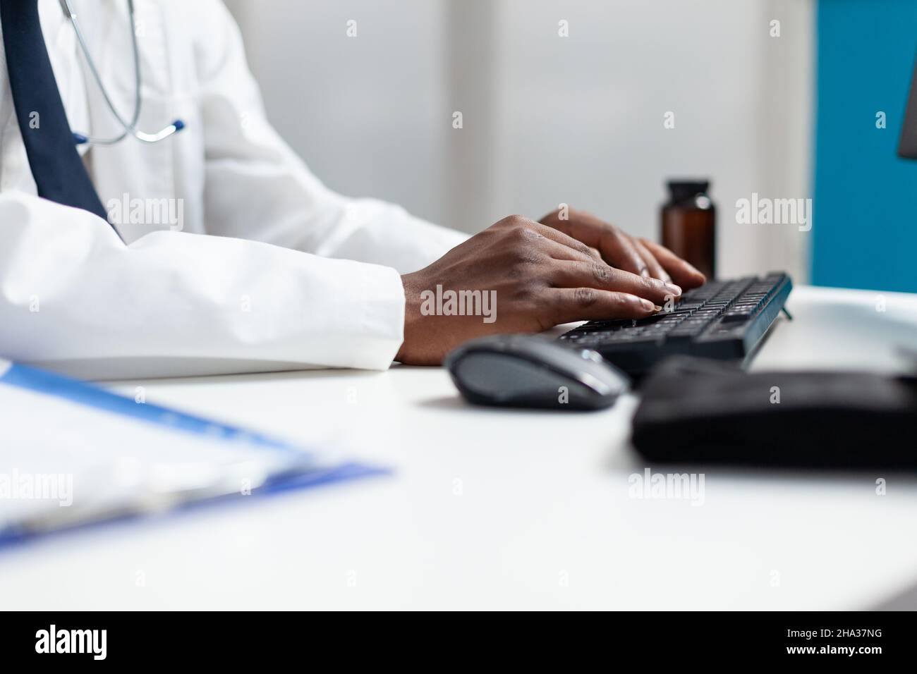 Closeup of african american doctor typing medicine prescription on ...