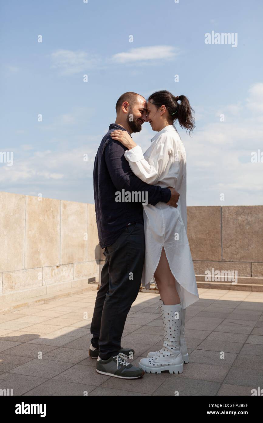 Romantic couple hugging while standing on tower rooftop celebrating ...