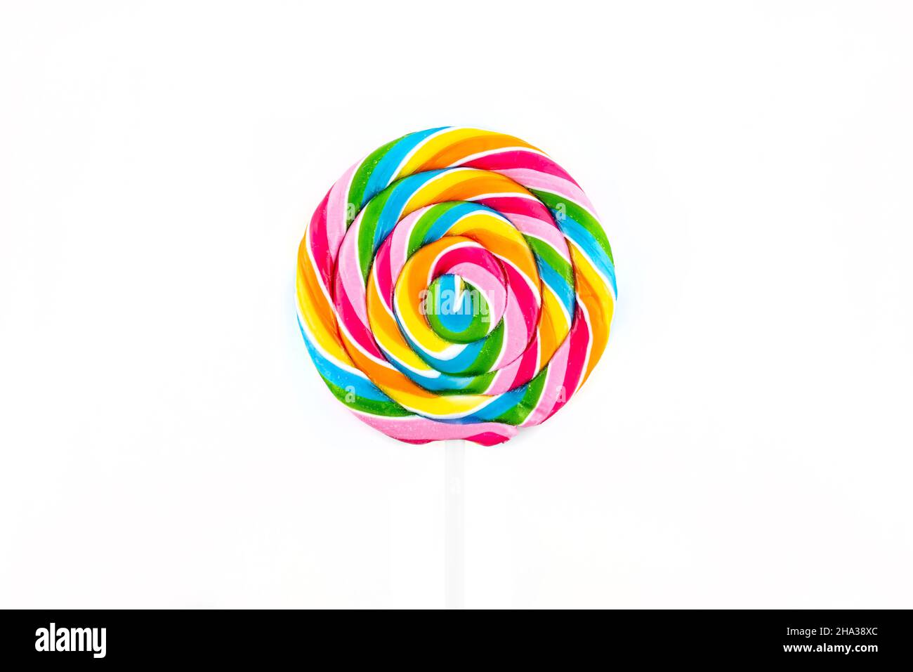 Sweet spiral-shaped colorful lollipop lying in the center, isolated on ...