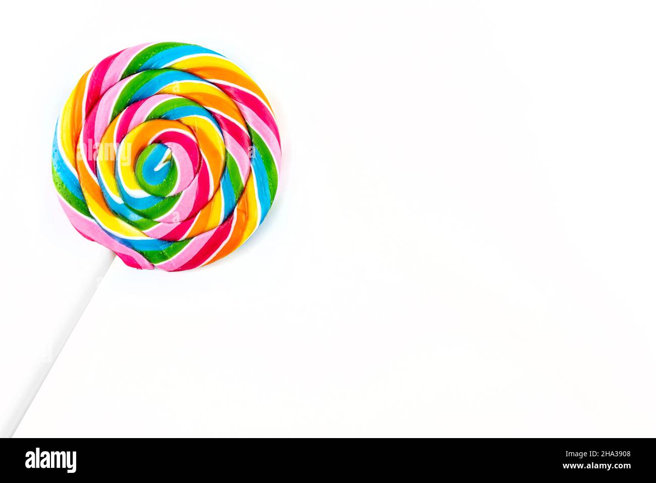 Sweet colorful spiral shaped lollipop lying in upper left corner ...
