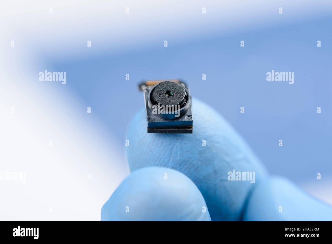 Smartphone front camera module on fingertip in laboratory, research or ...