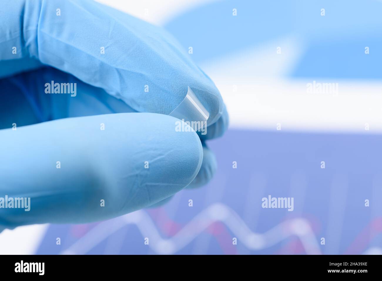 Scientist bend flexible transparent plastic like thin film material in ...