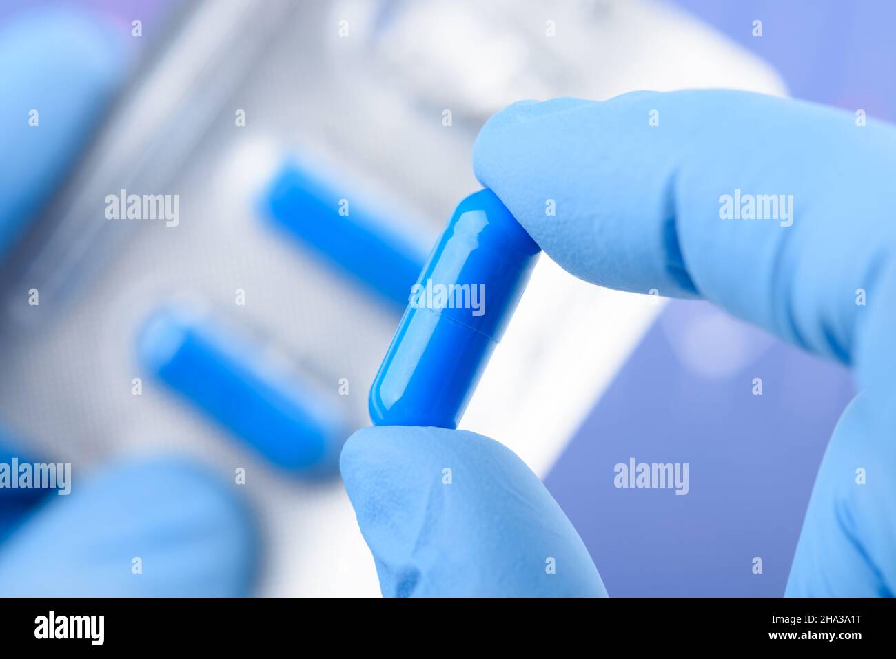 Scientist hold in hand blue pill capsule Stock Photo - Alamy