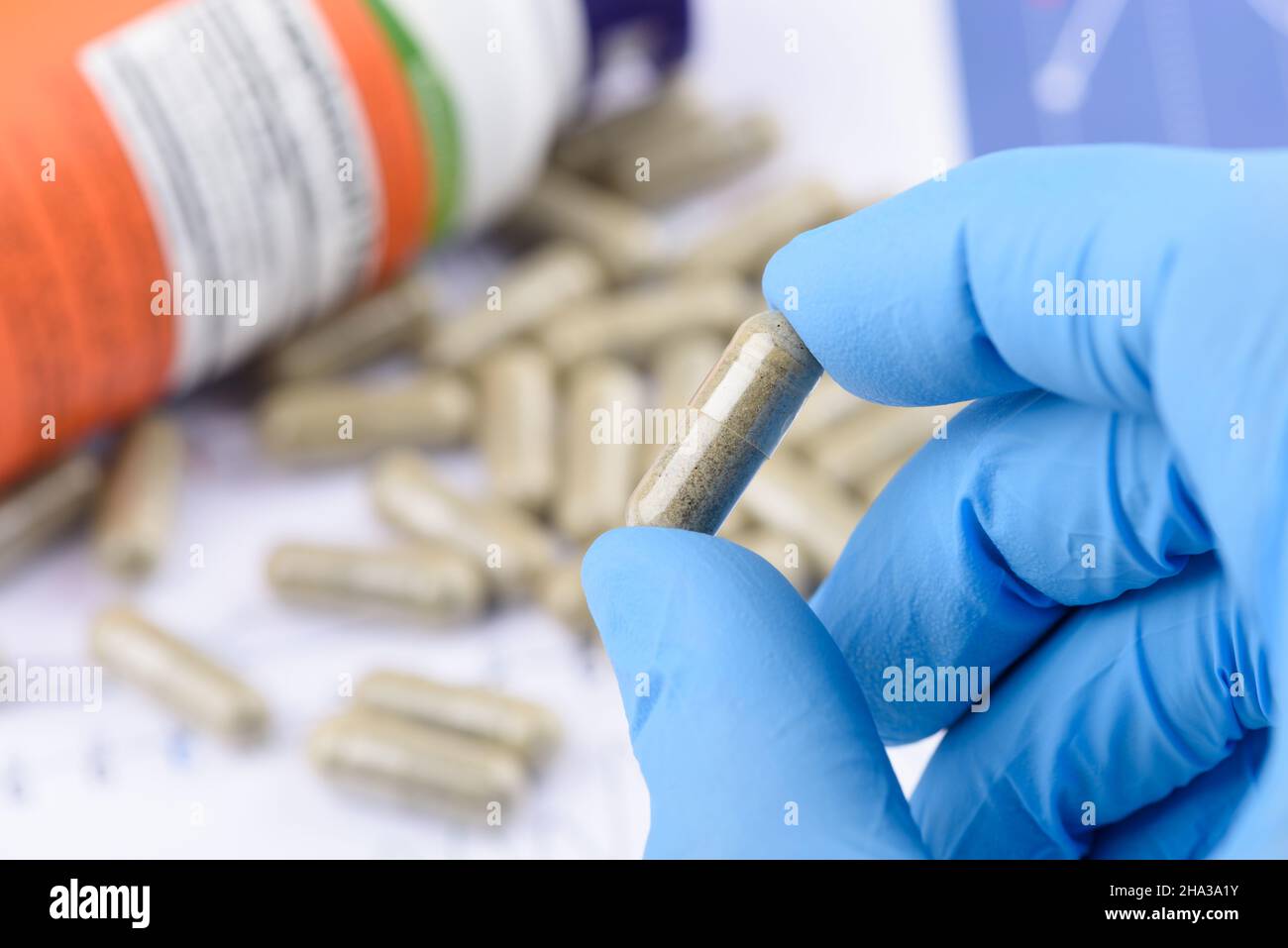 Supplement capsule in scientist hands, with bottle and pills on ...