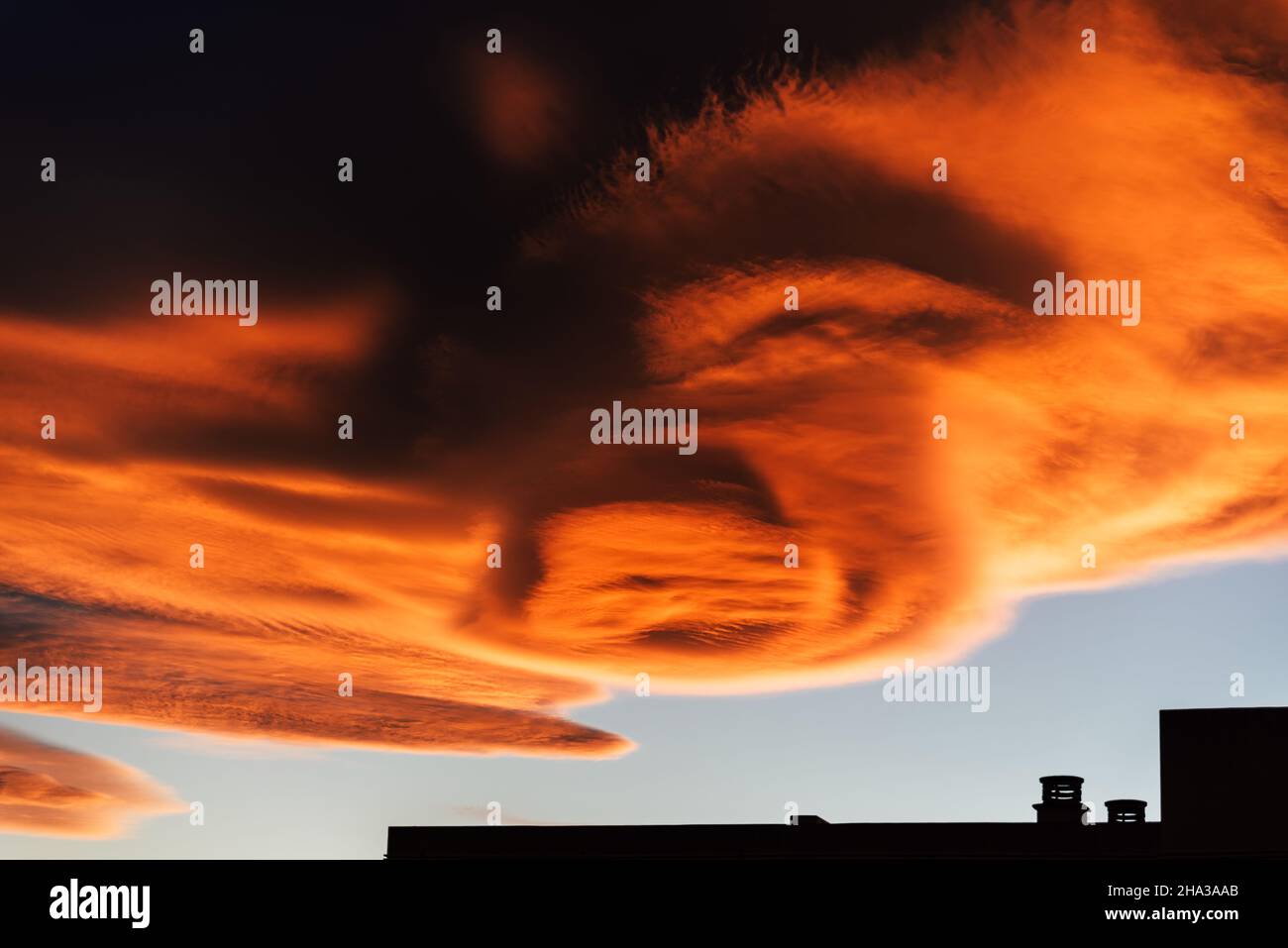 Beautiful sunset sky with red and orange clouds behind the city ...