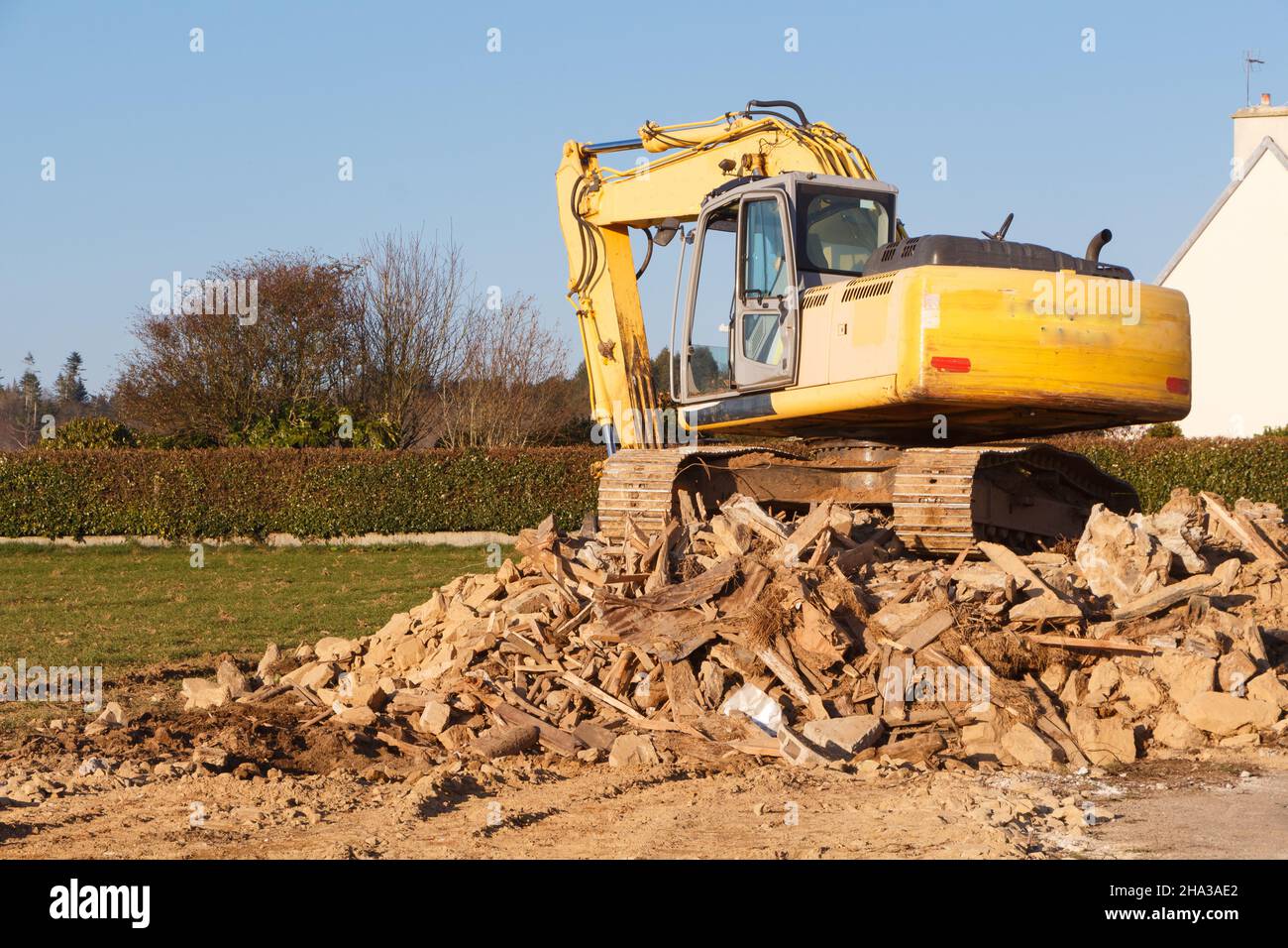 Digger on a heap of rubble in a field Stock Photo - Alamy