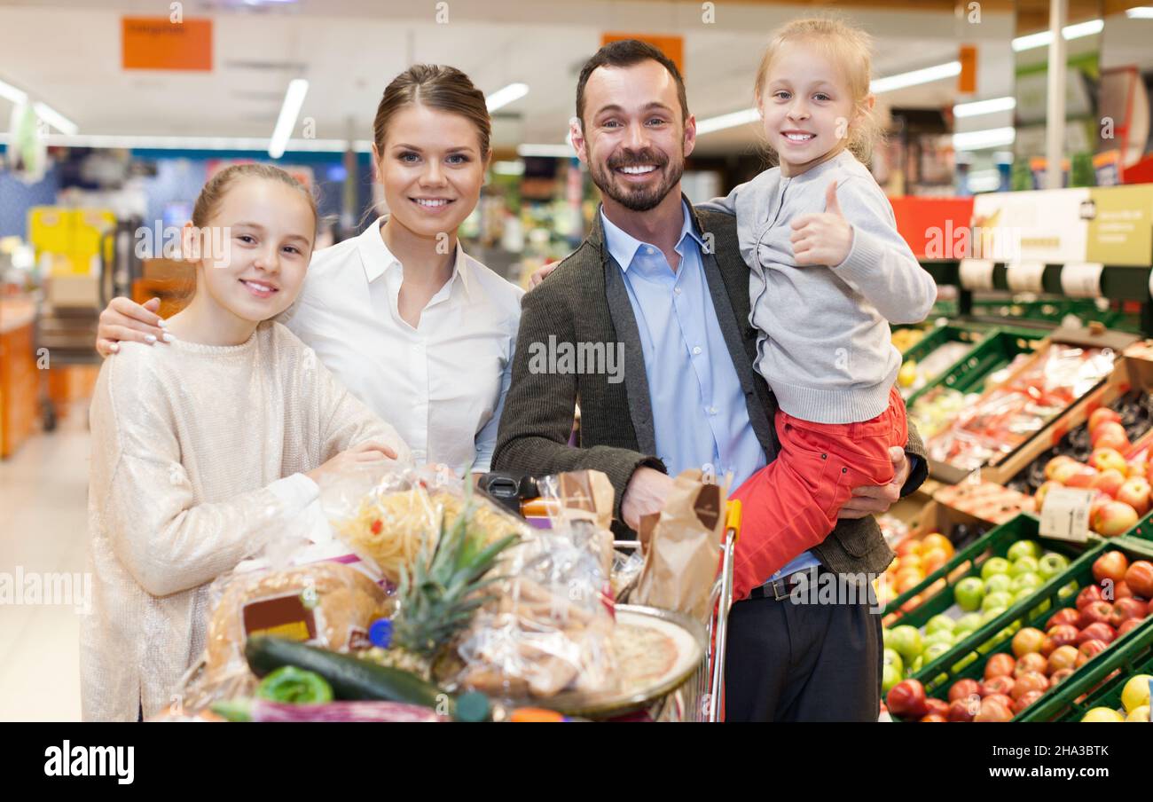 Smiling family with their children standing together in the shop Stock ...