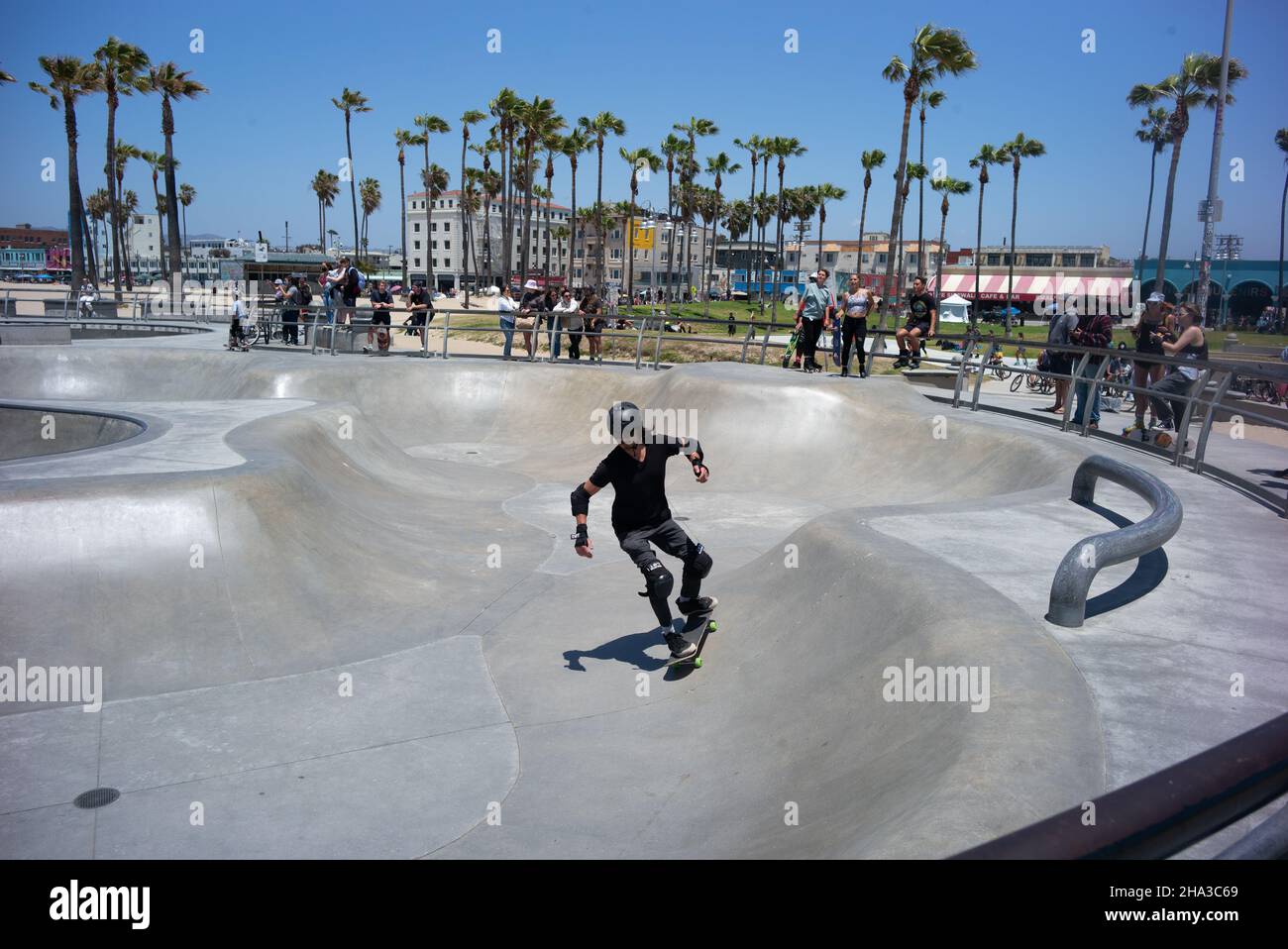 Venice, California A young man roller skating in the skater ramps on ...