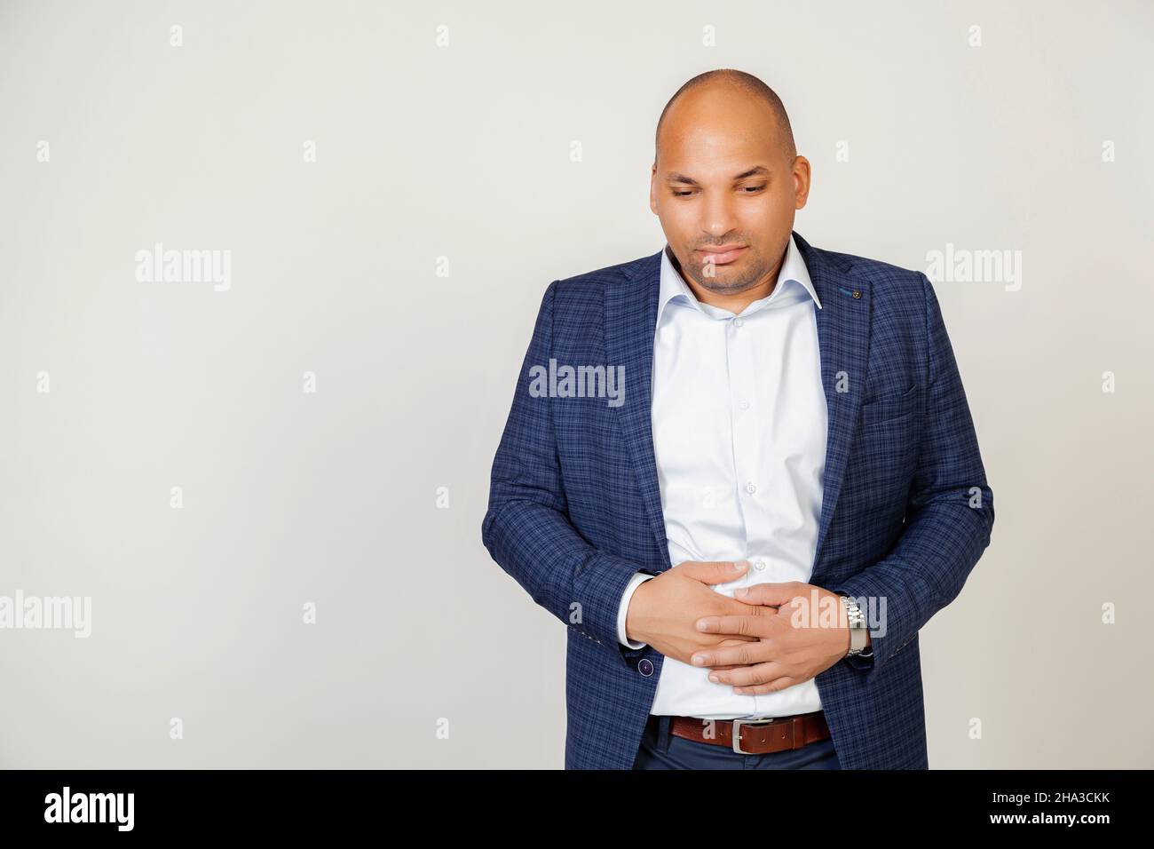 Young African American man with hand on his stomach due to indigestion ...
