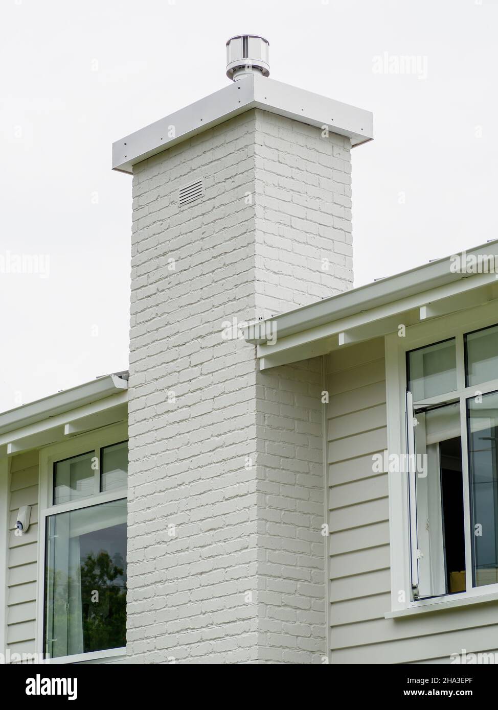 white brick masonry chimney with metal insert Stock Photo - Alamy