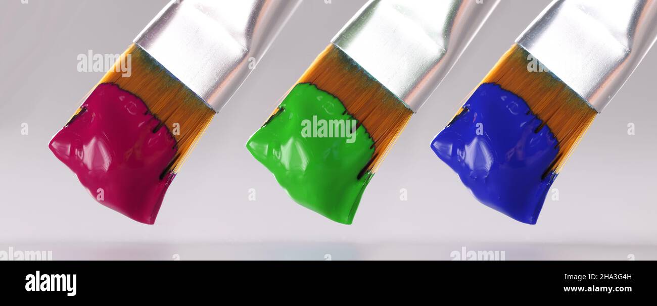 Three brushes with different paint colors. Artistic paints of different ...