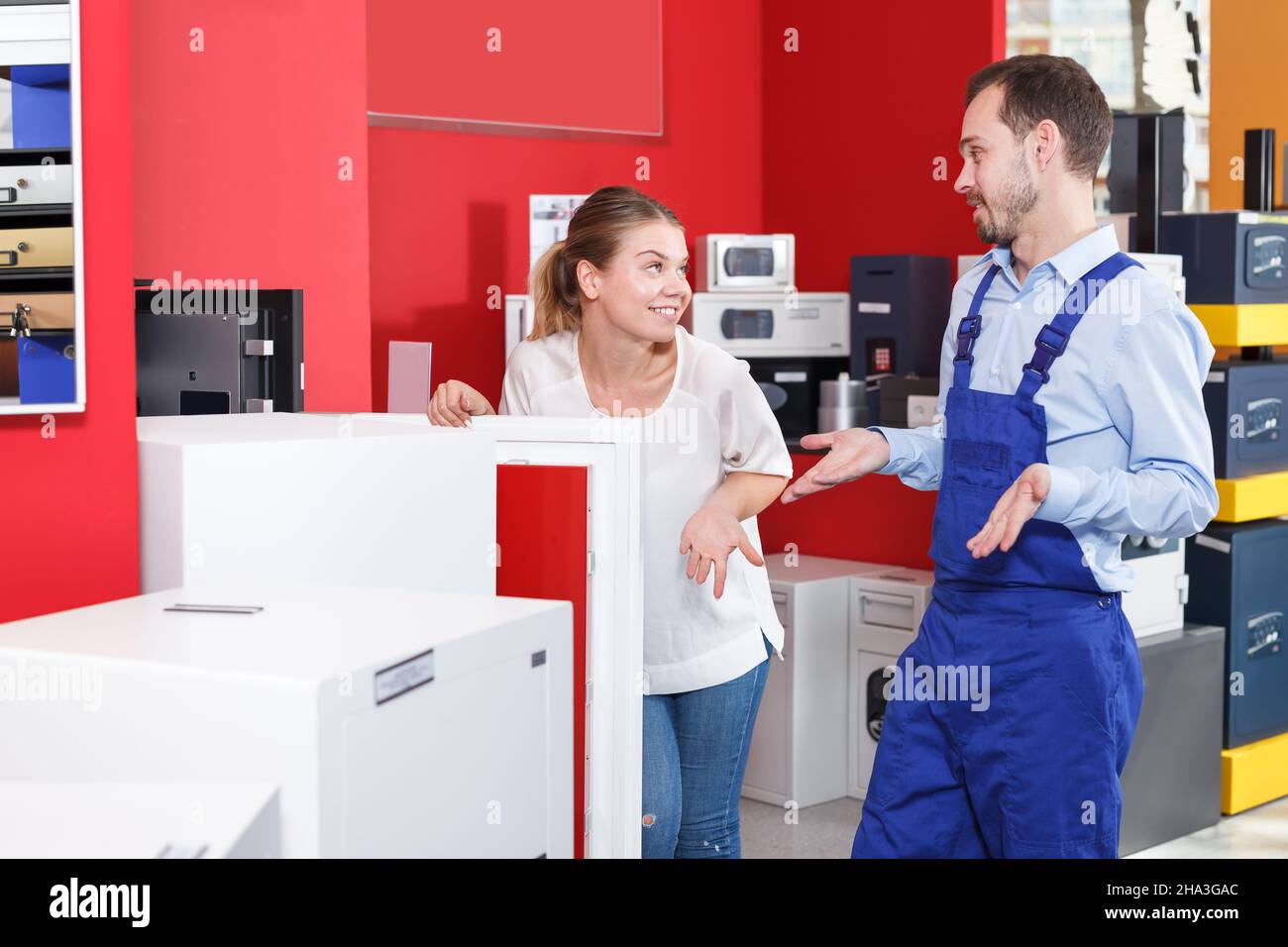 Man seller helping to glad female client Stock Photo - Alamy