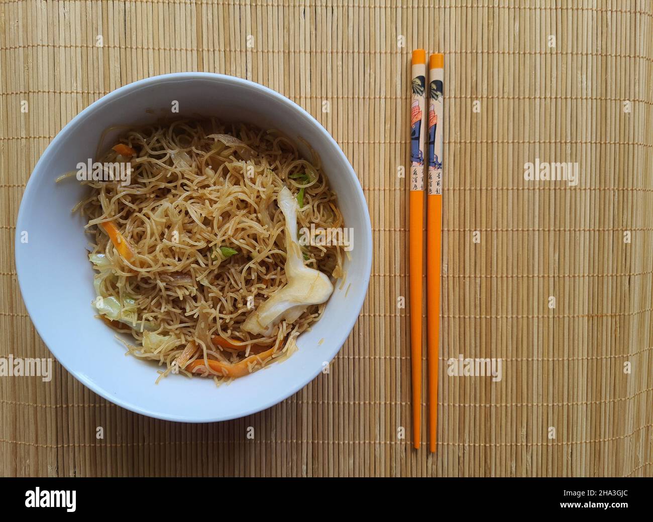 Bifum vegetable noodles in a white crockery bowl with two chopsticks on ...
