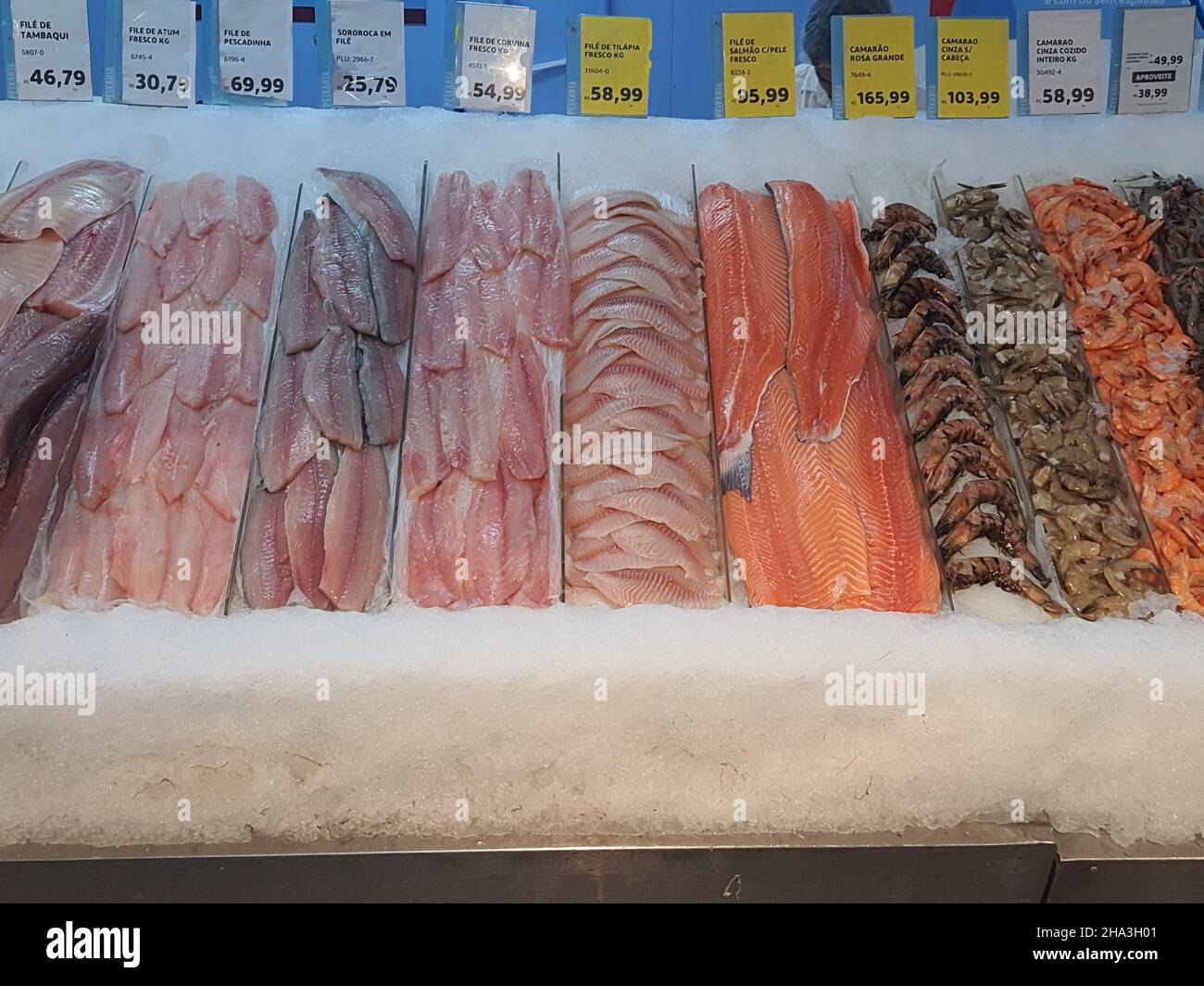 Fresh fish on ice, different types, colorful, whole and fillets, in a ...