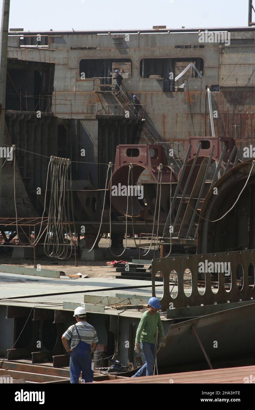 Shipbuilding pier and crane. Workers working on the pier Stock Photo ...