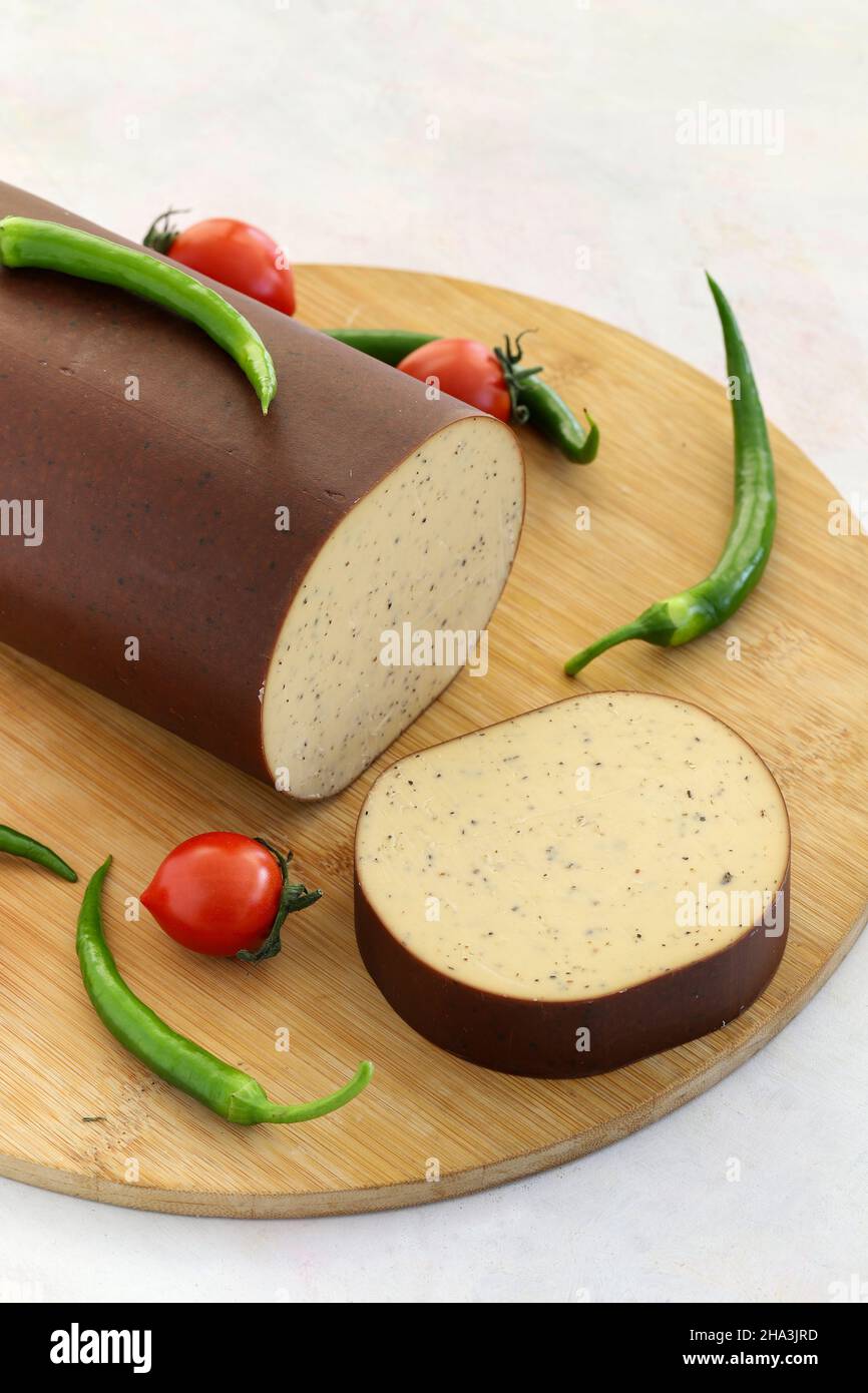 Smoked cheese with peppers on a white background. Local name biberli ...