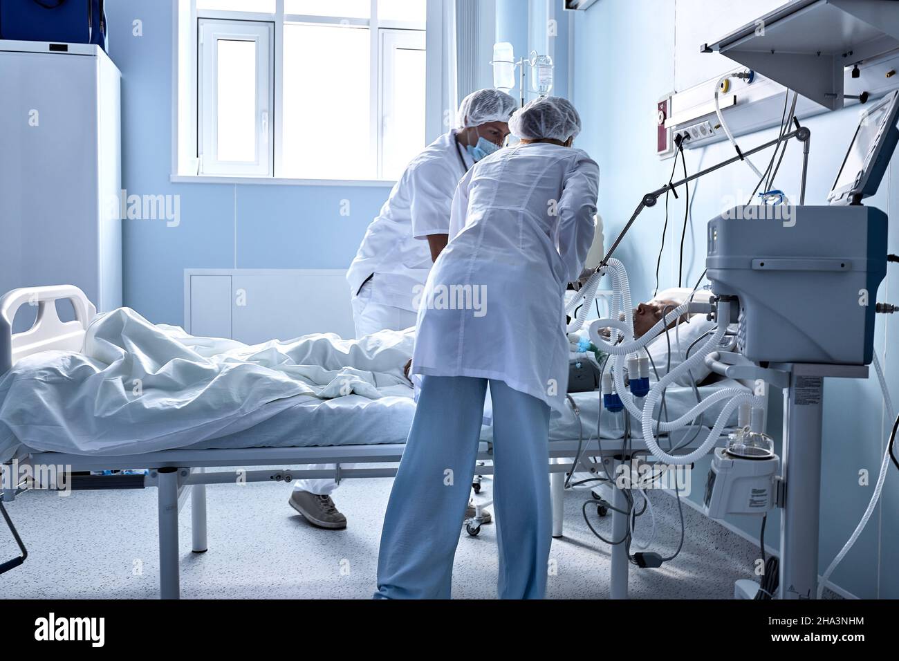 Two friendly doctors nurses help injured sick person, in hospital ward ...