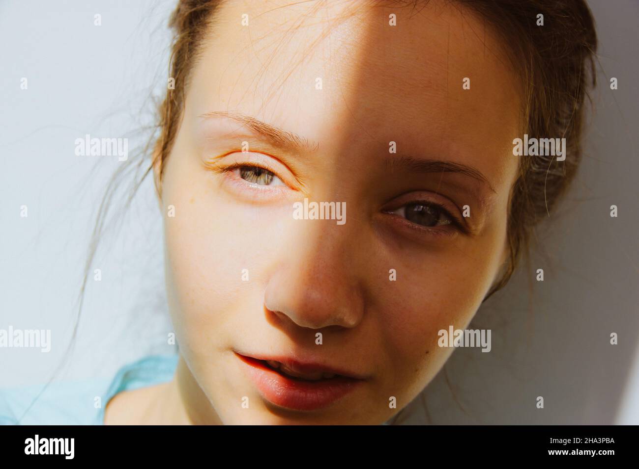 A woman smiling at camera. Contrasting shadow on half face. Cute girl ...
