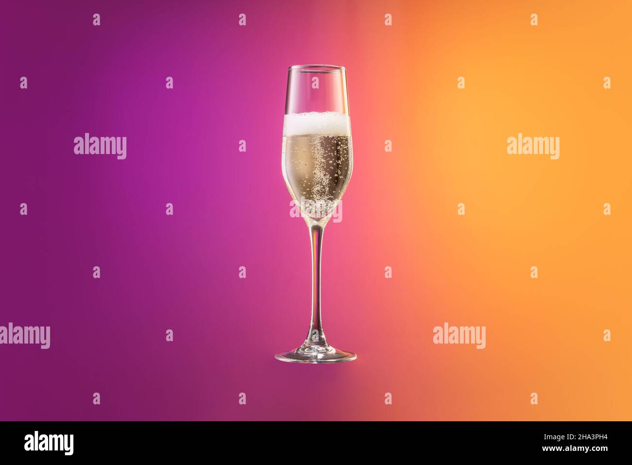 Glass with cold champagne with bubbles isolated over gradient purple ...