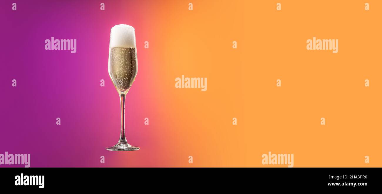 Glass with cold champagne with bubbles isolated over gradient purple ...