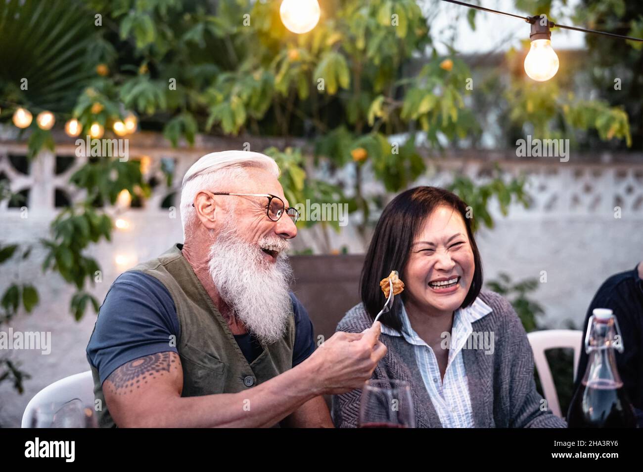 Happy senior friends having fun at dinner house party - Elderly ...
