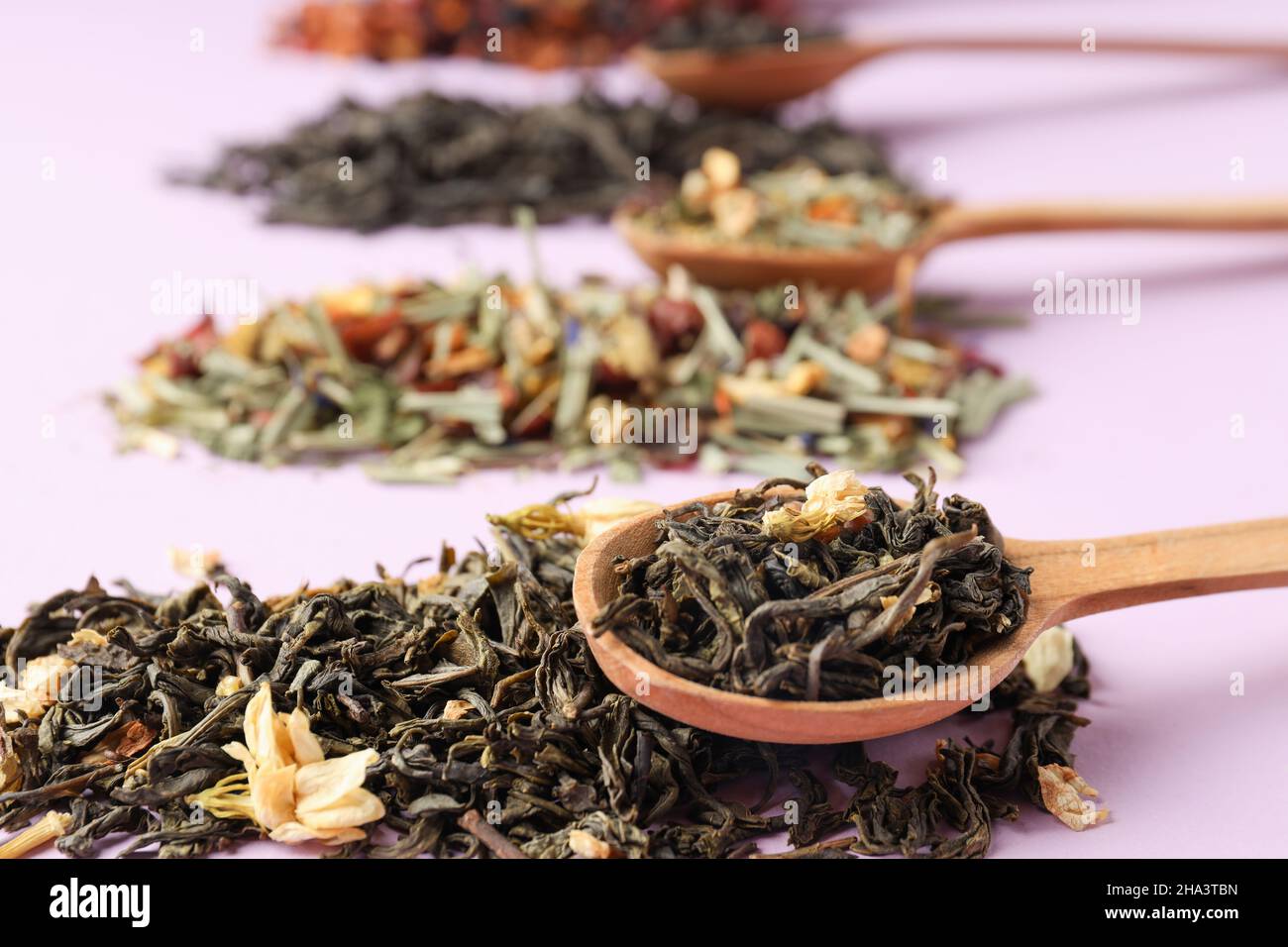Concept of cooking tea with different types of tea on purple background ...