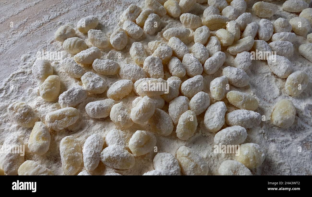 Raw uncooked potato gnocchi with flour on a table Stock Photo - Alamy