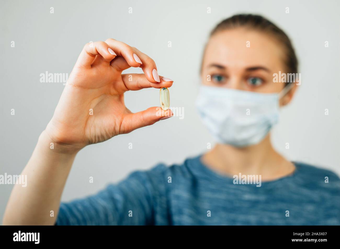 Girl in a medical mask holds a pill in her hands close-up Stock Photo ...