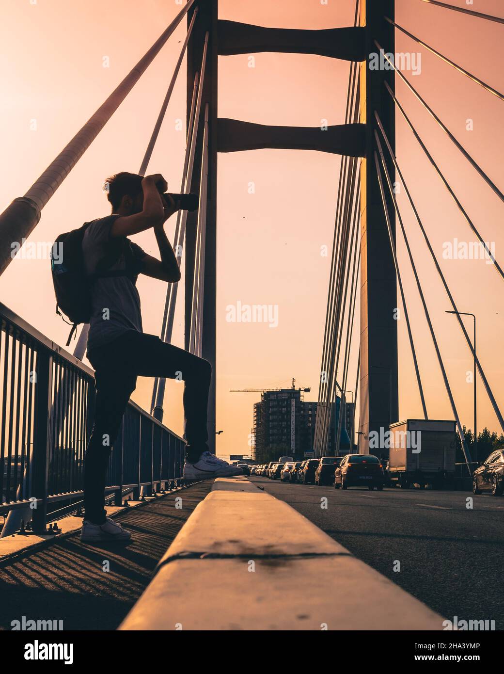 Photographer capturing the mesmerizing sunset from a bridge Stock Photo ...