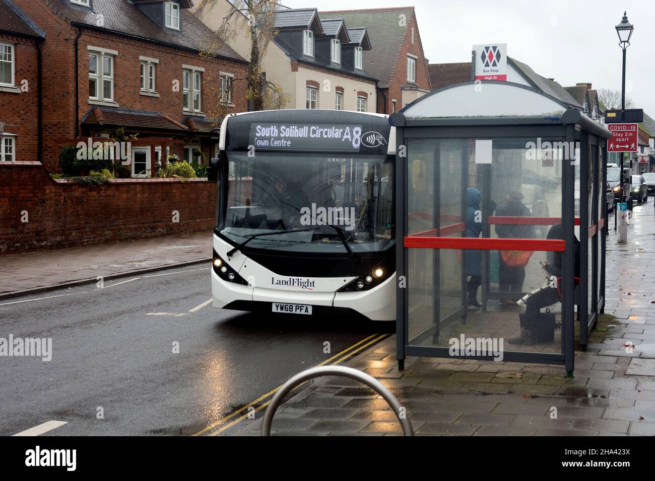 A local bus in High Street on a wet winter`s day, Knowle, West Midlands ...