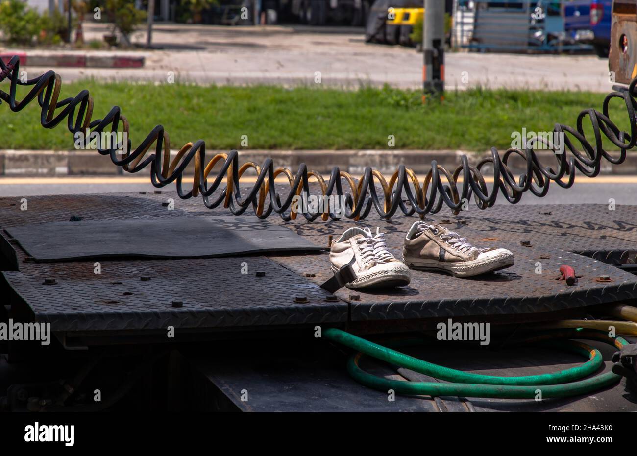 An old pair of dirty white sneakers shoe left on behind a truck ...