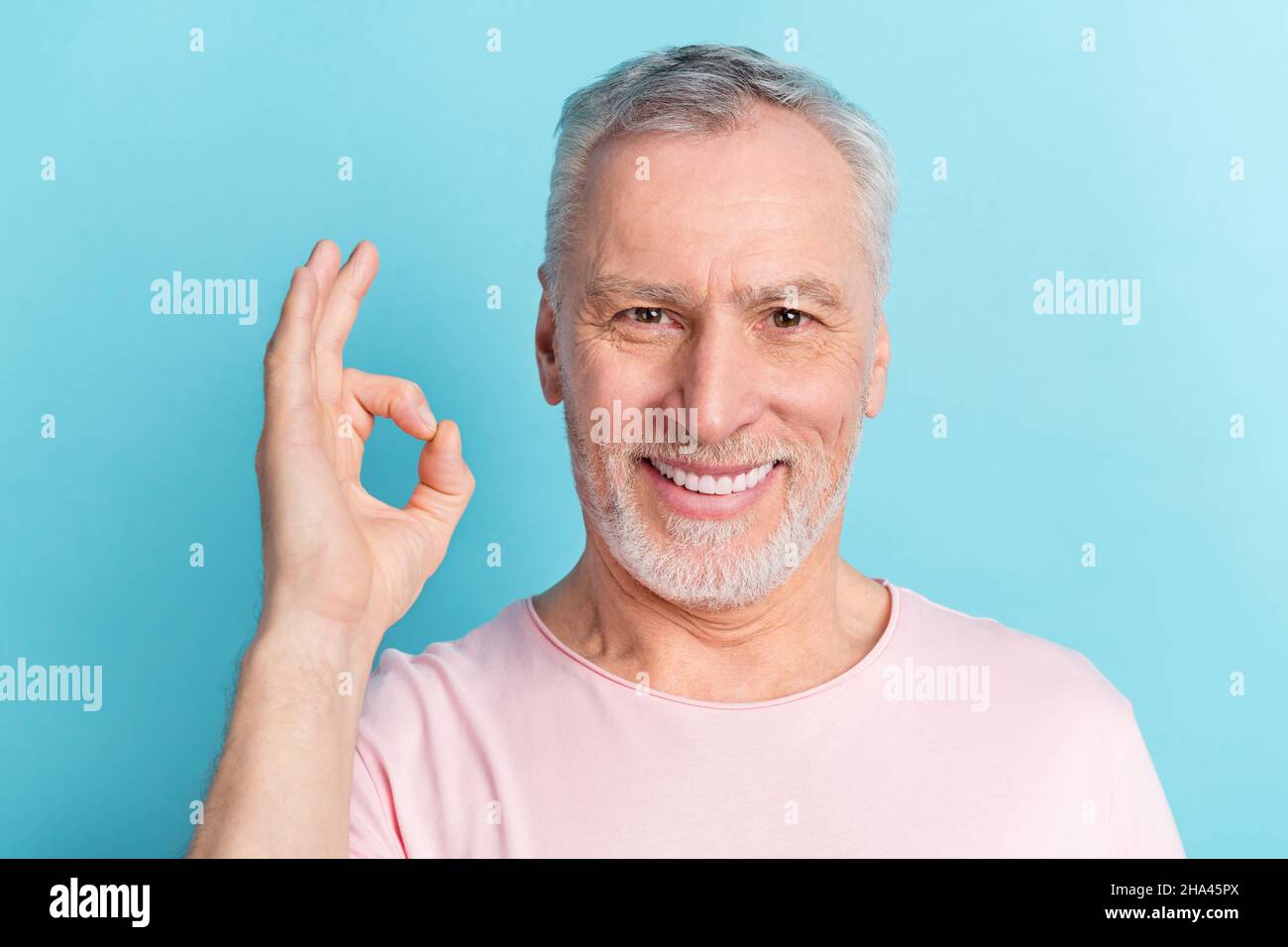 Photo portrait smiling elder man in pink t-shirt showing okay sign ...