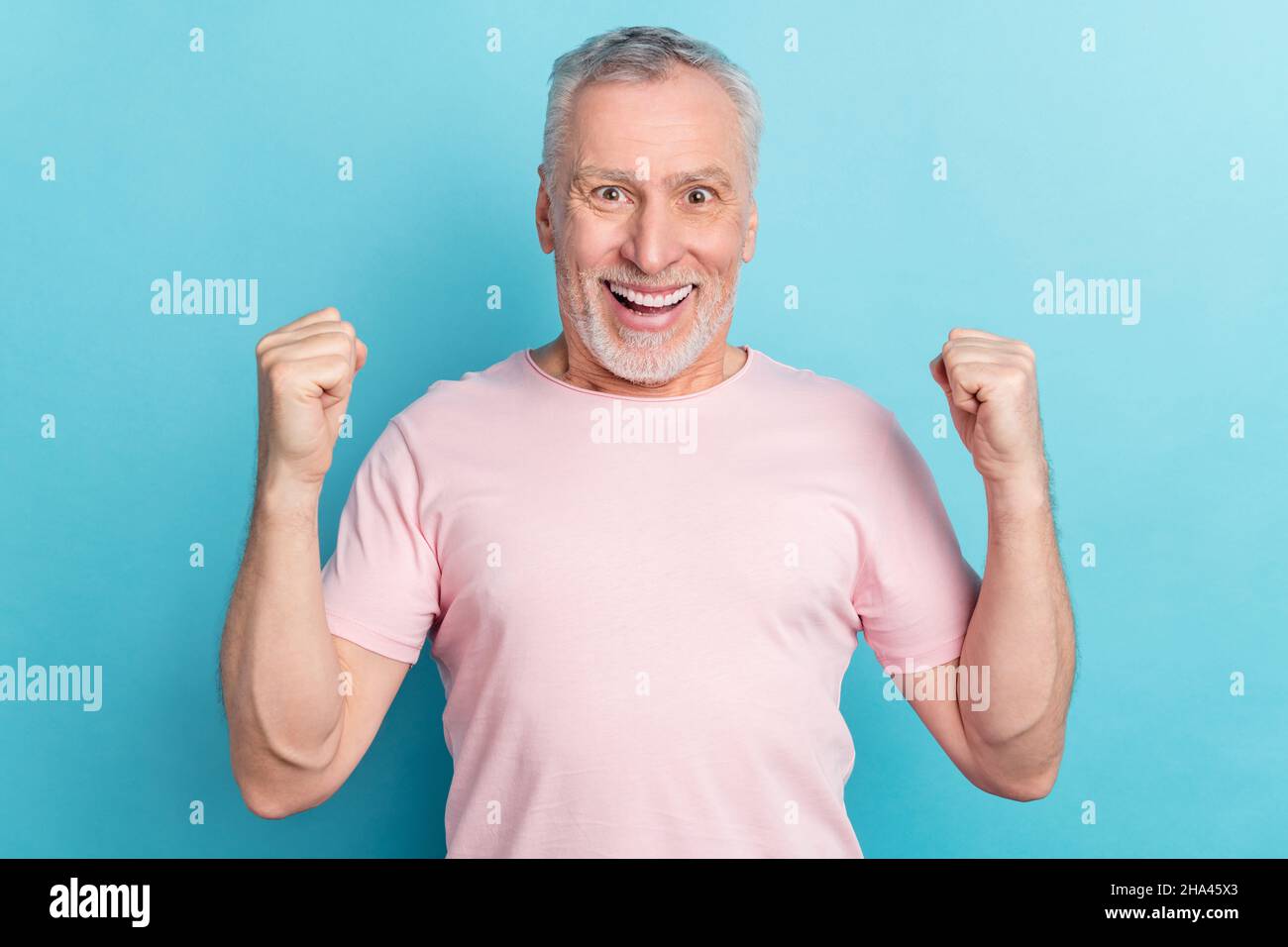 Photo portrait smiling elder man in pink t-shirt gesturing like winner ...