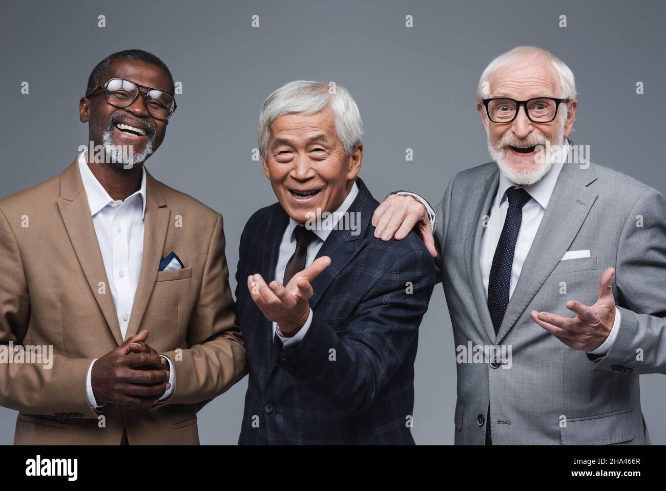 senior multiethnic businessmen with outstretched hands near smiling ...