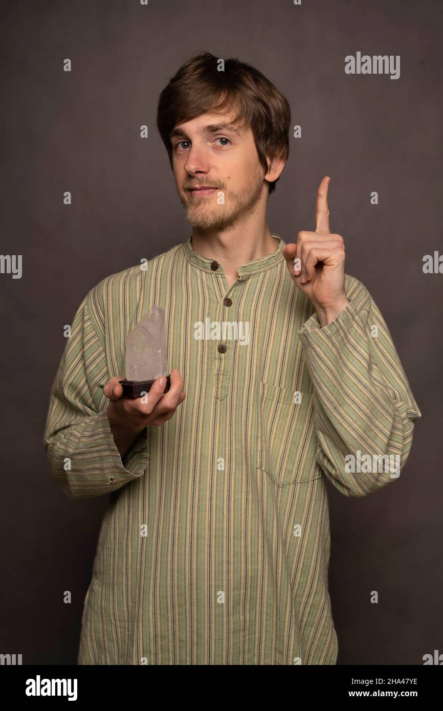 Young handsome tall slim white man with brown hair holding crystal hand ...