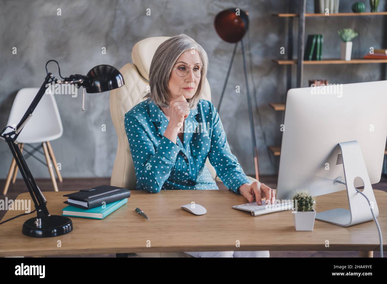 Photo of serious charming concentrated old woman look computer think ...