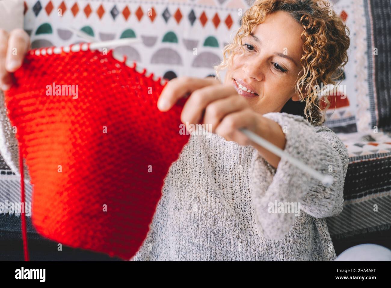 adult attractive woman at home in knitting work activity using colorful ...