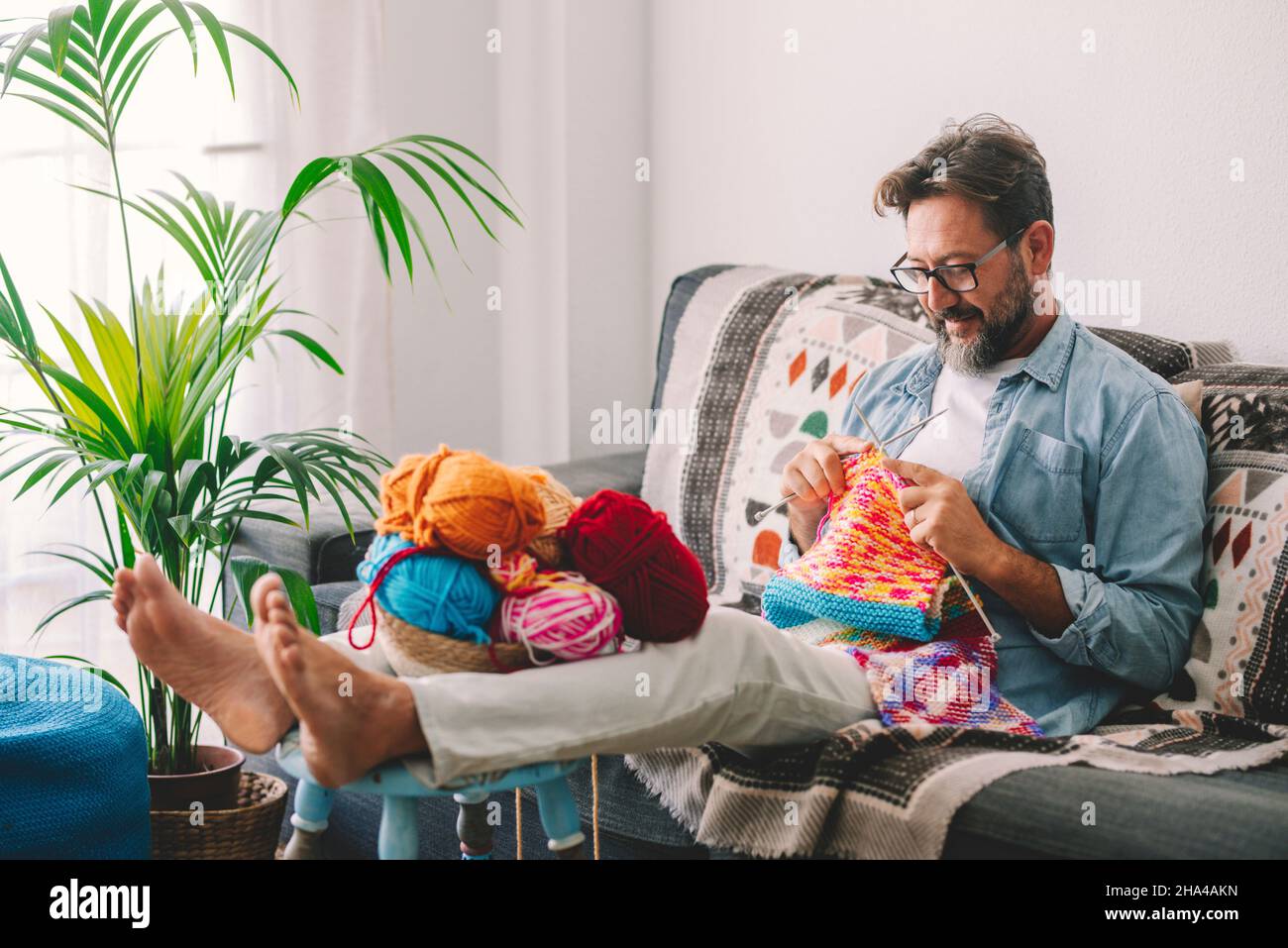 man at home having relax doing knit work hobby activity sitting on the ...