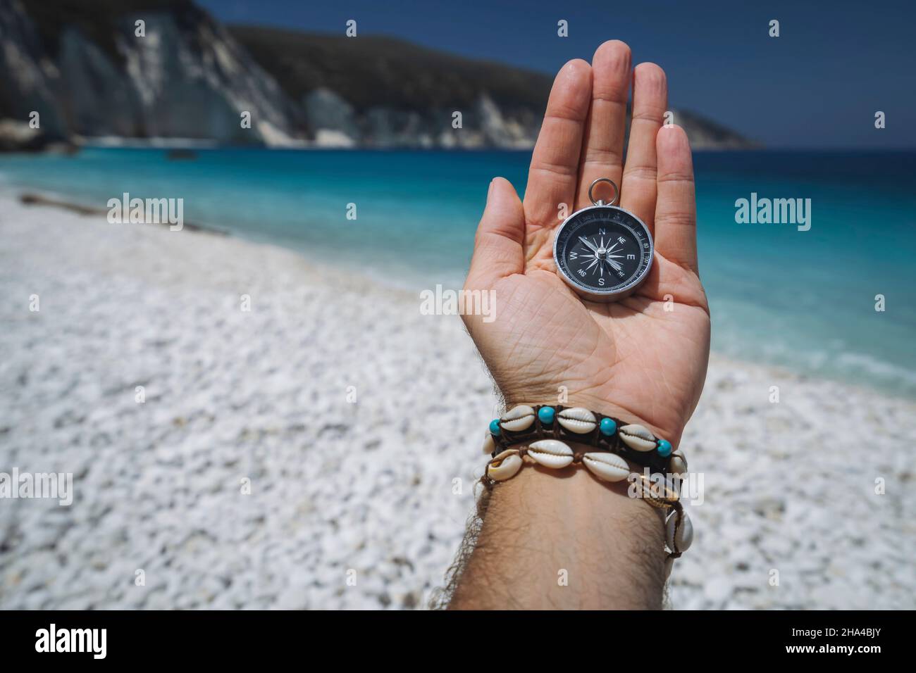 hand holding a compass on the beach in background Stock Photo - Alamy