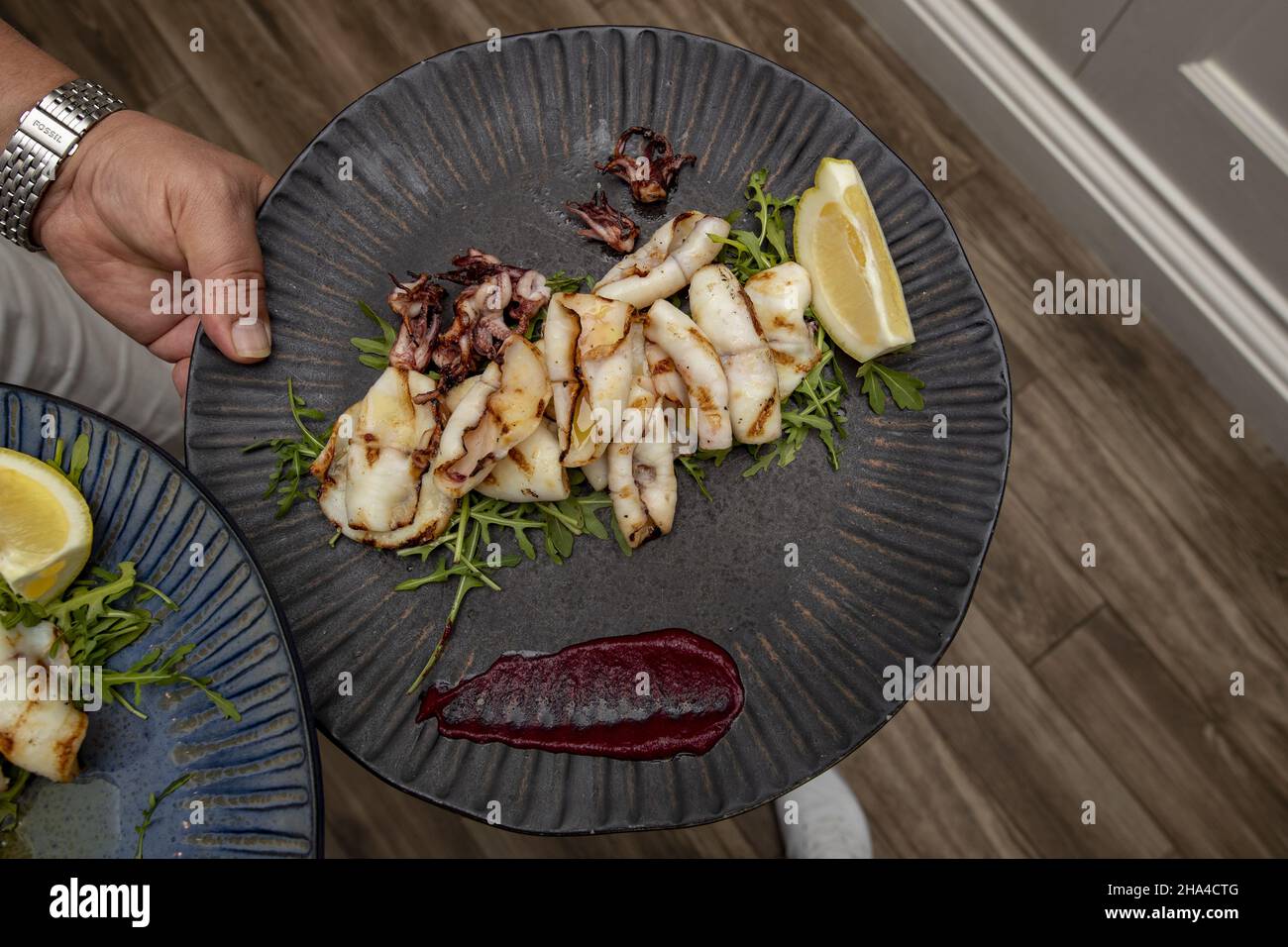 Top view of a tasty Calamari with lemon served in a plate in a man's ...