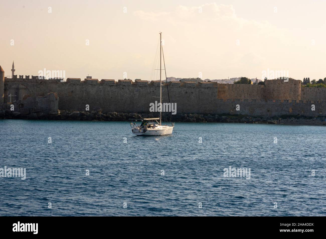 White boat sailing close to the coast blue aegean sea in Greece Stock ...