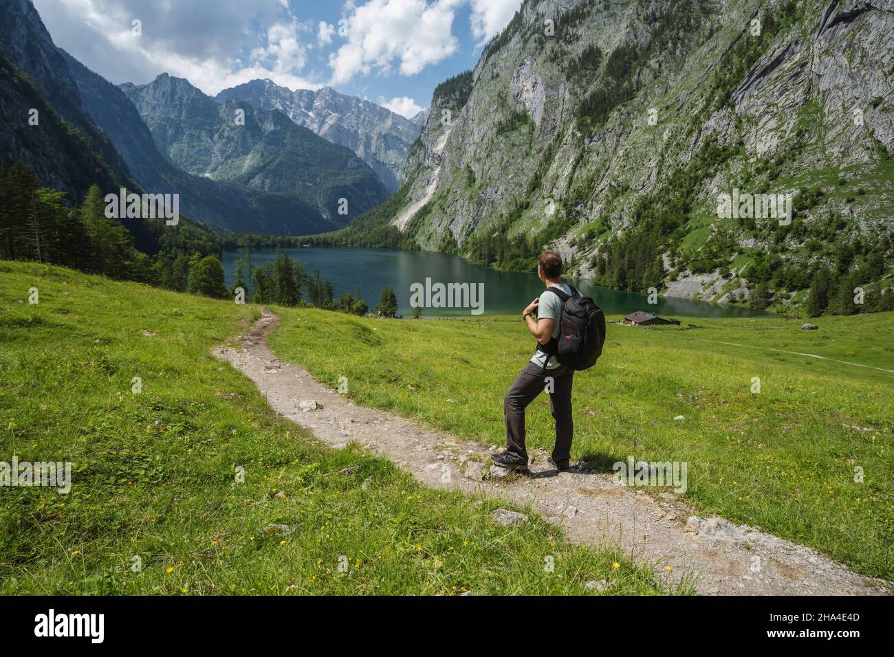 man with backpack on hiking trail enjoying hinterer gosausee ...