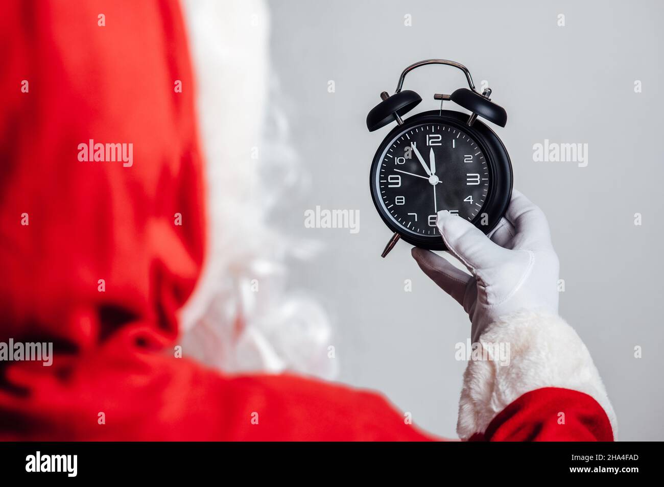 Santa Claus holding an alarm clock Stock Photo - Alamy