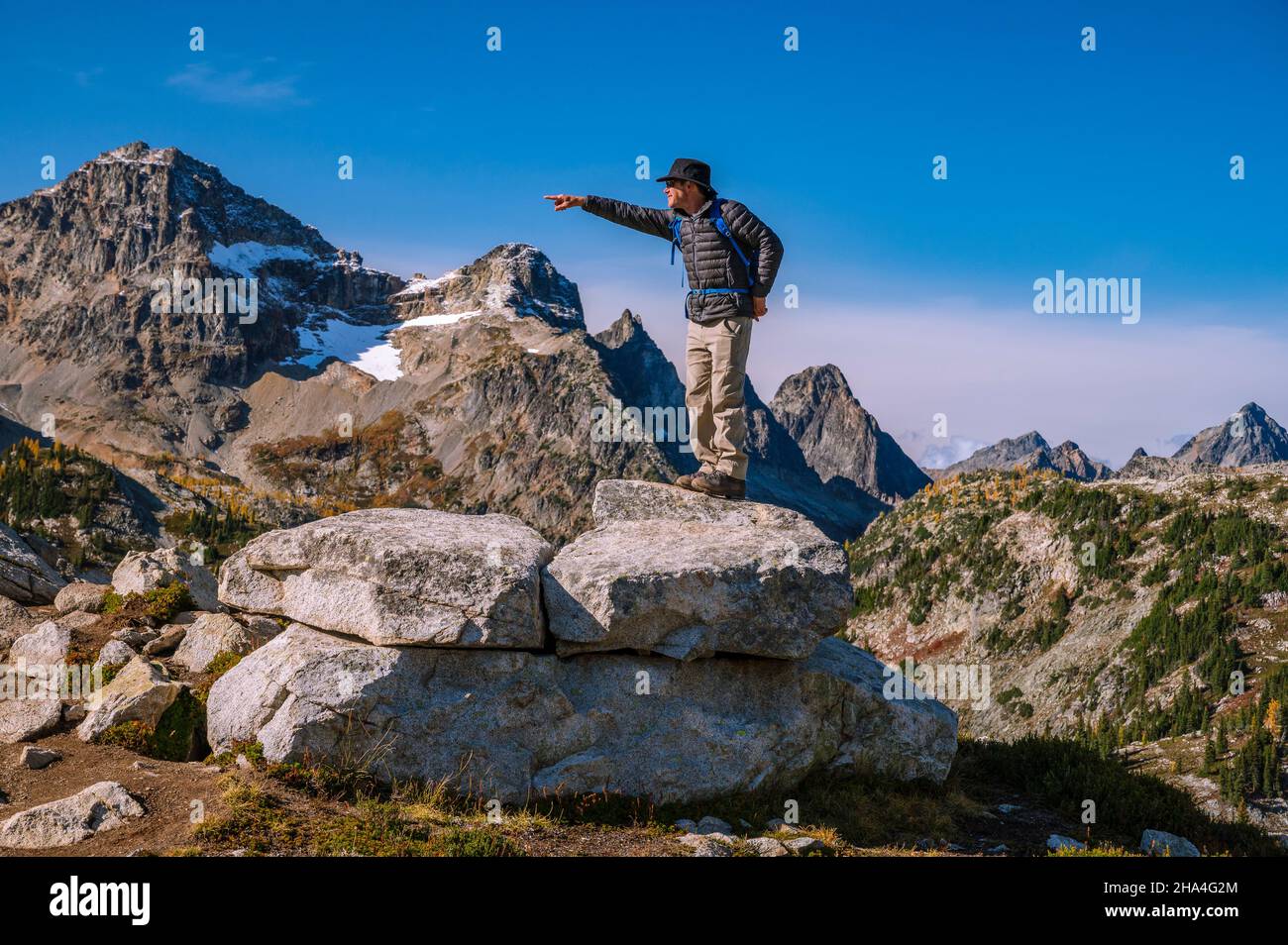 Guy standing on a ridge being goofy Stock Photo - Alamy