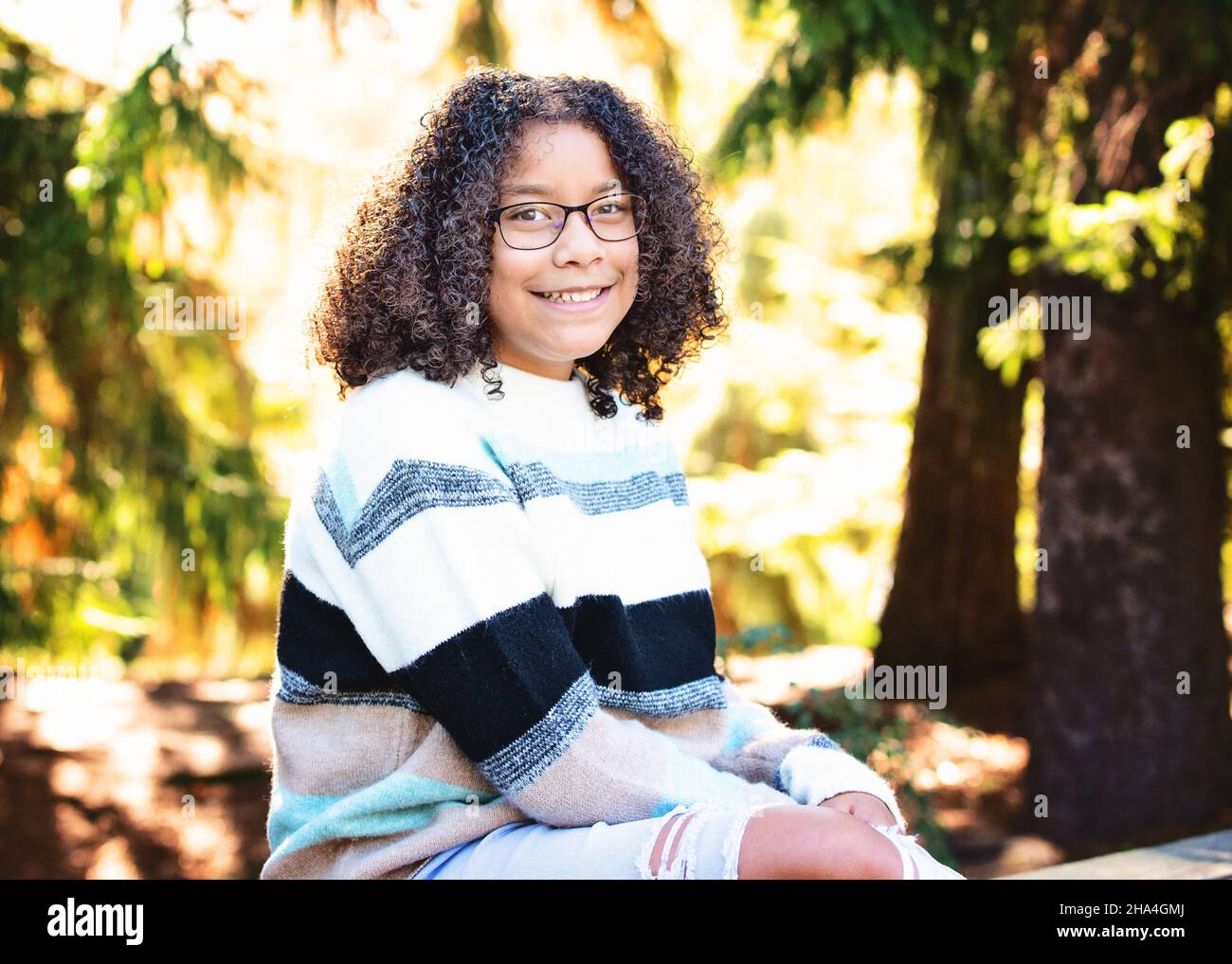 Happy tween girl in a sweater outdoors in fall colors Stock Photo - Alamy