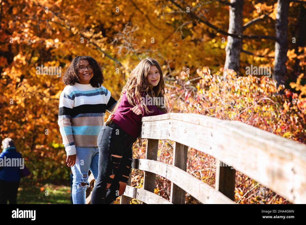Two tween girls on a bridge in fall colors Stock Photo - Alamy