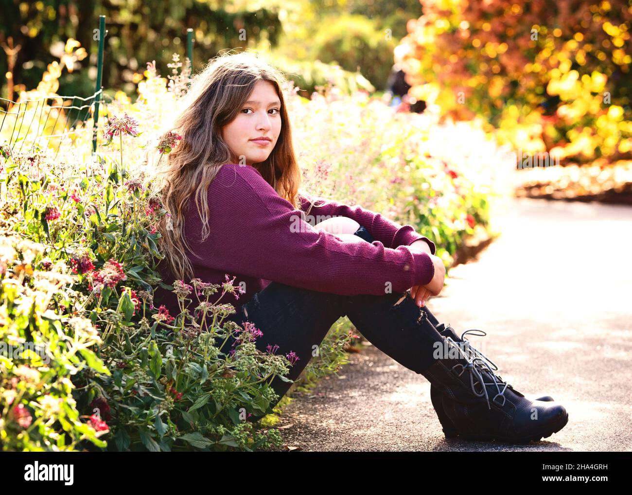 Beautiful tween girl sitting on path in fall colors Stock Photo - Alamy