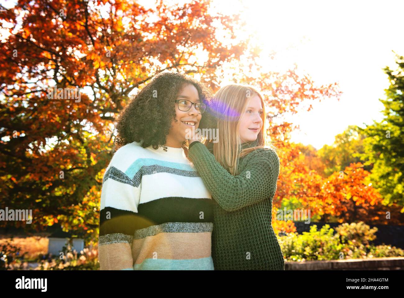Two pretty tween girls laughing together outdoors in fall colors Stock ...